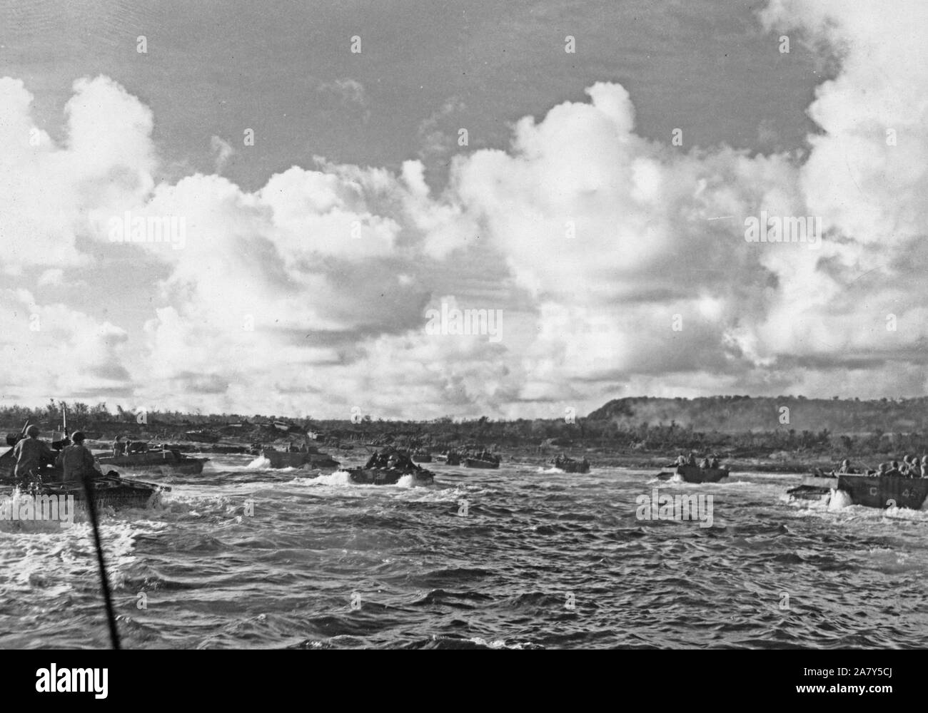 Men and supplies speed toward Tinian island aboard amphibious tractors ...