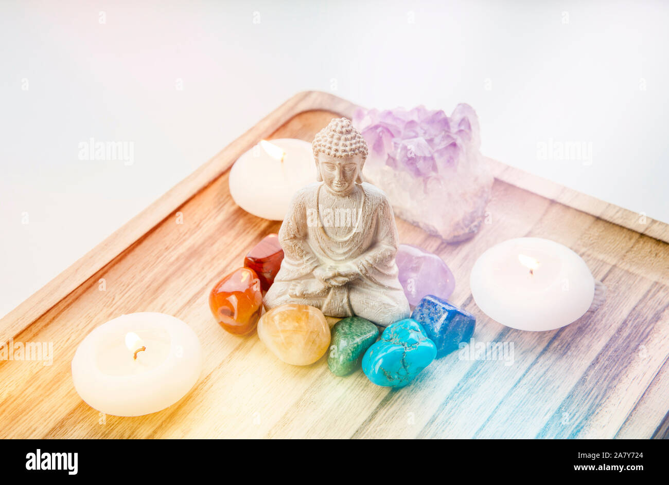 All seven chakra colors crystals stones around sitting Buddha figurine ...