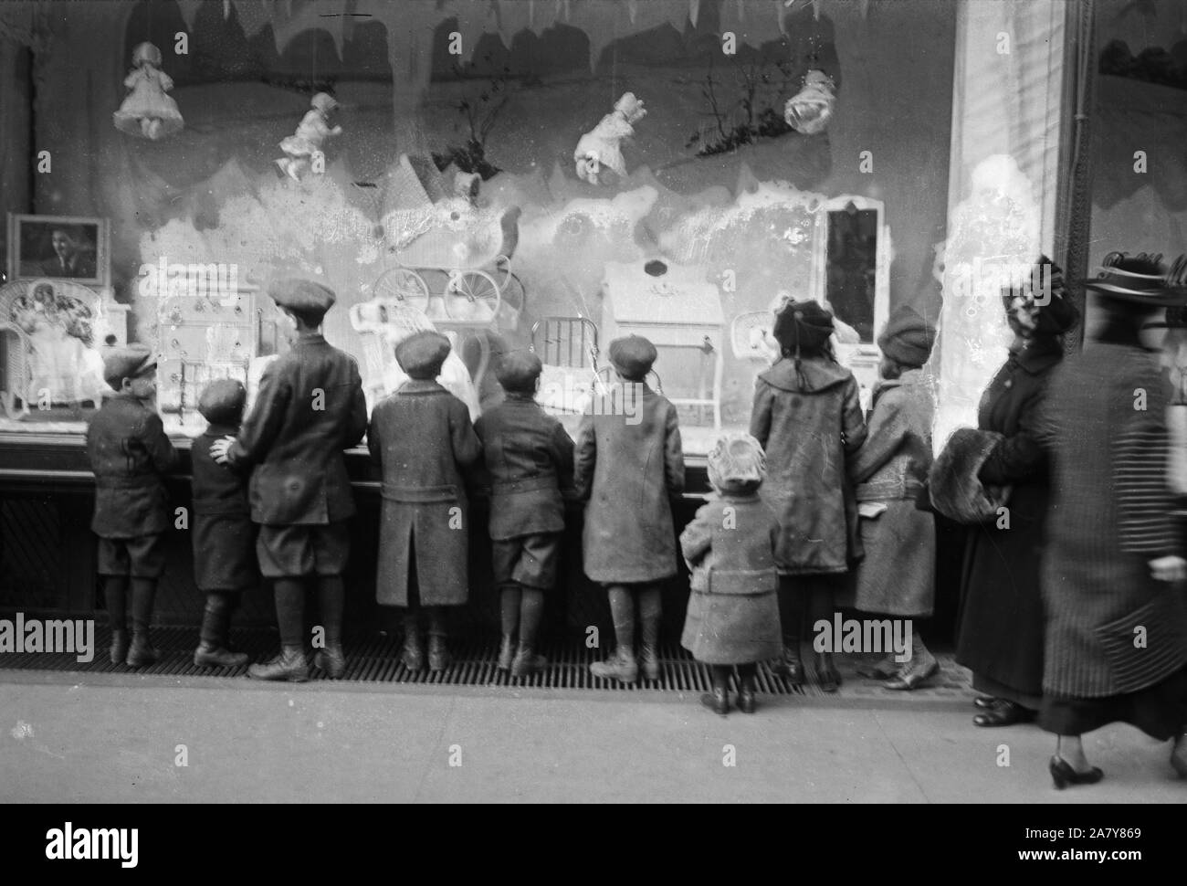 Children looking into store window along a New York City street with ...
