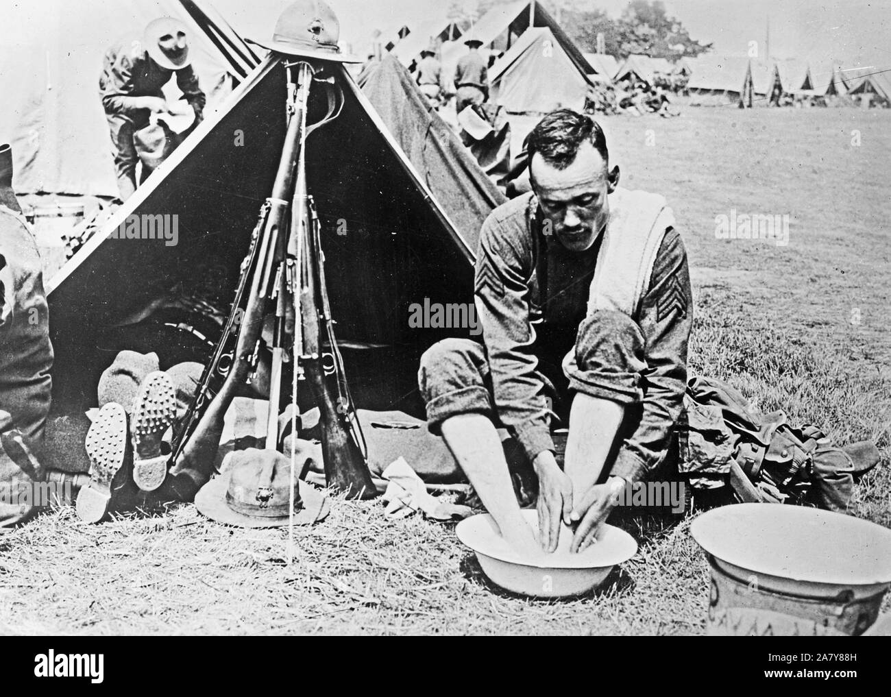 American Marine washing his feet as another sleeps in pup tent in ...