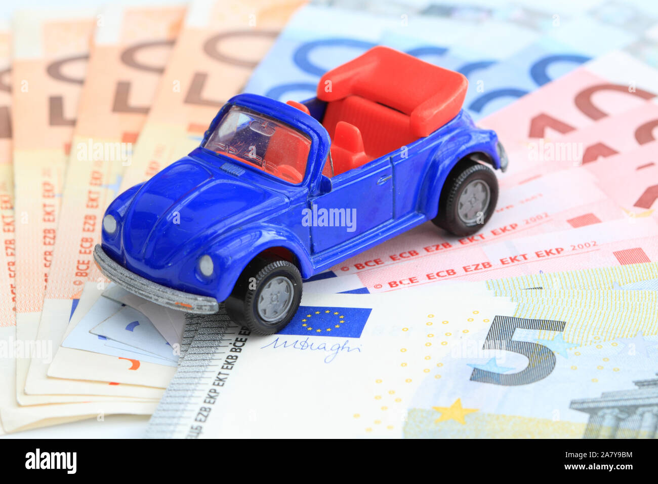 a small car with money Stock Photo - Alamy