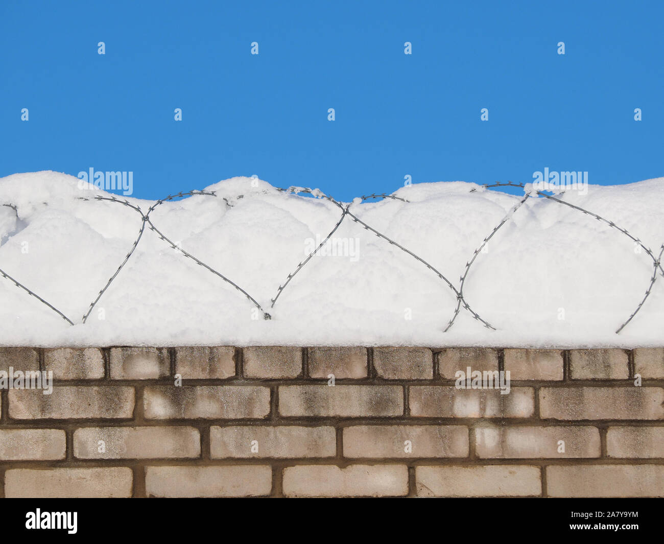 brick wall with barbed wire in the snow Stock Photo - Alamy