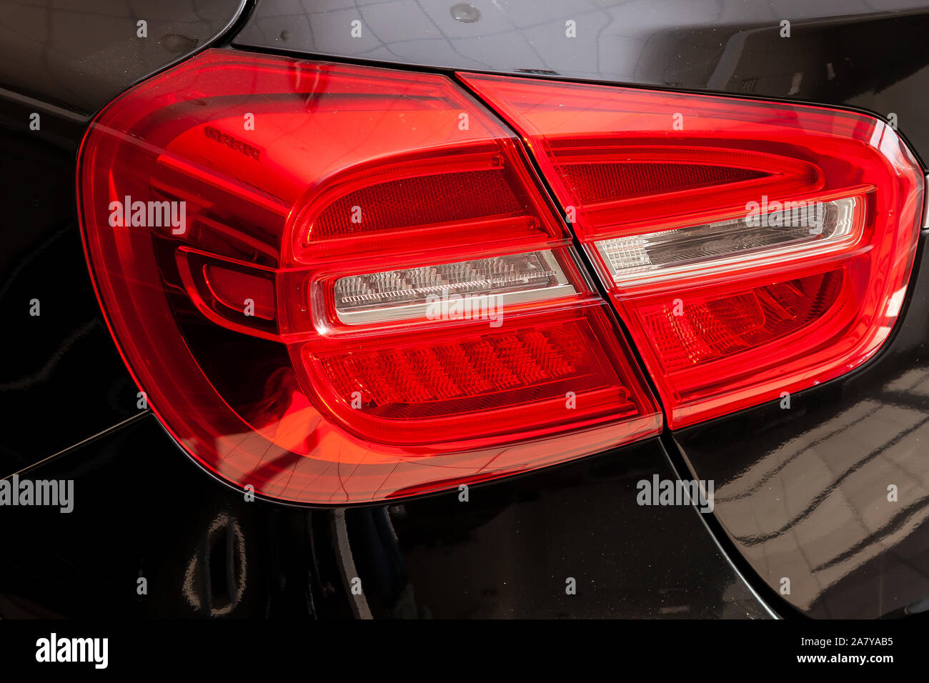 Close-up on the rear LED brake light of red color on a black car in the ...