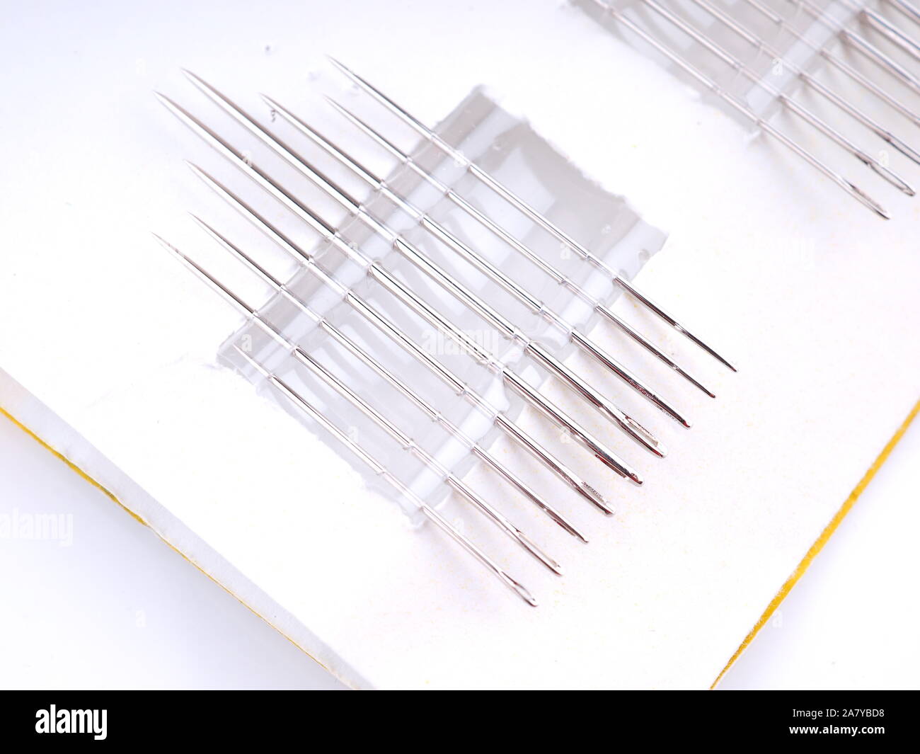 sewing needles on white background Stock Photo - Alamy
