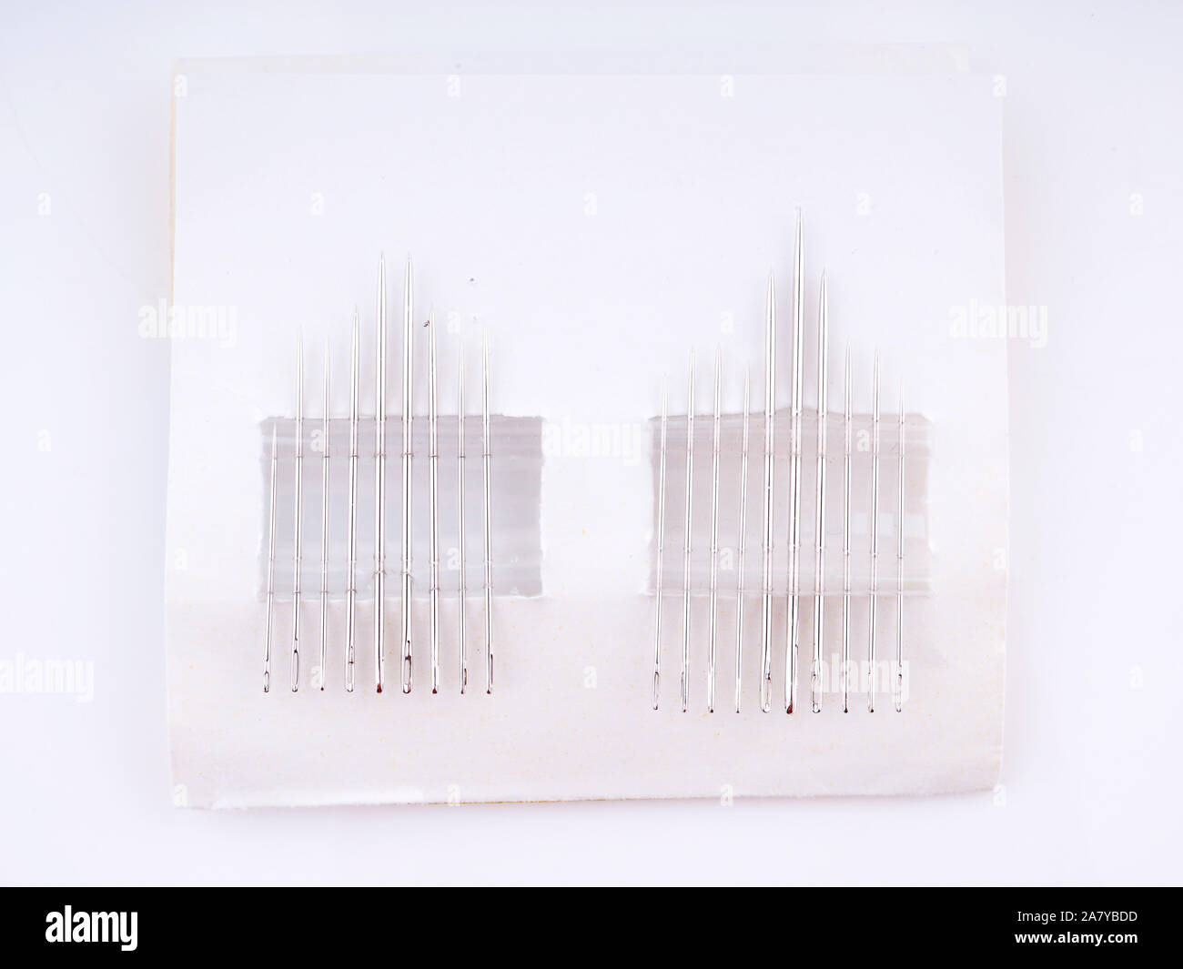 sewing needles on white background Stock Photo - Alamy