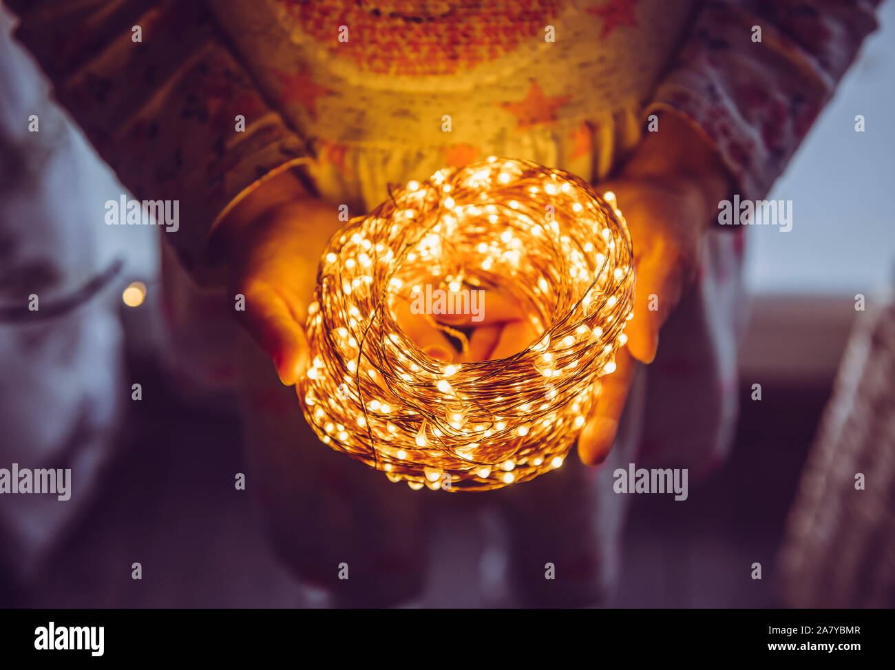 Close up top view of person holding roll of wire micro LED string ...