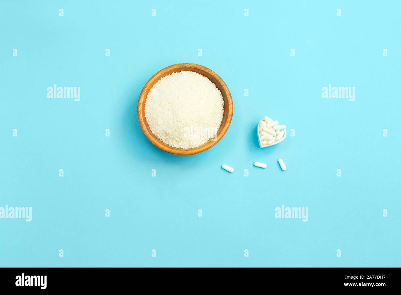 Collagen powder and pills on blue background. Sports preparations for ...