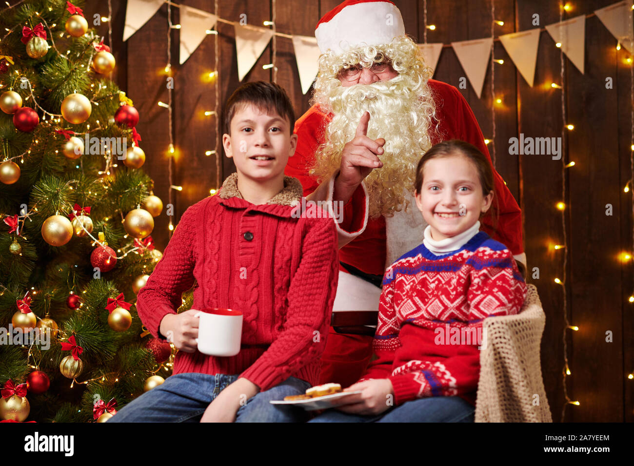 Santa Claus and child boy and girl posing together indoor near ...