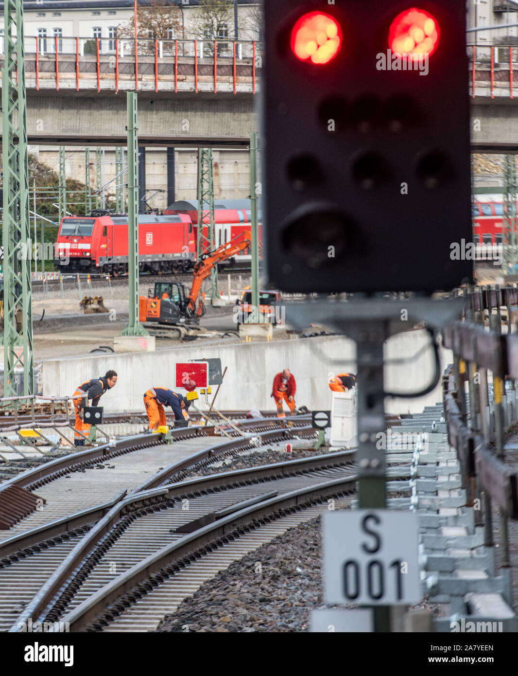 Ulm, Germany. 05th Nov, 2019. A train passes track workers at the main ...