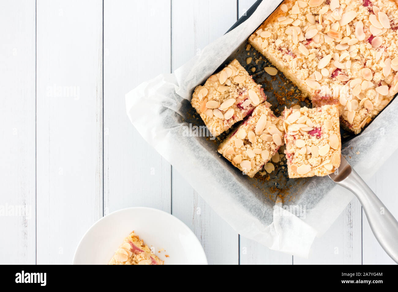 Homemade rhubarb crumble cake in a baking tray lined with parchment ...