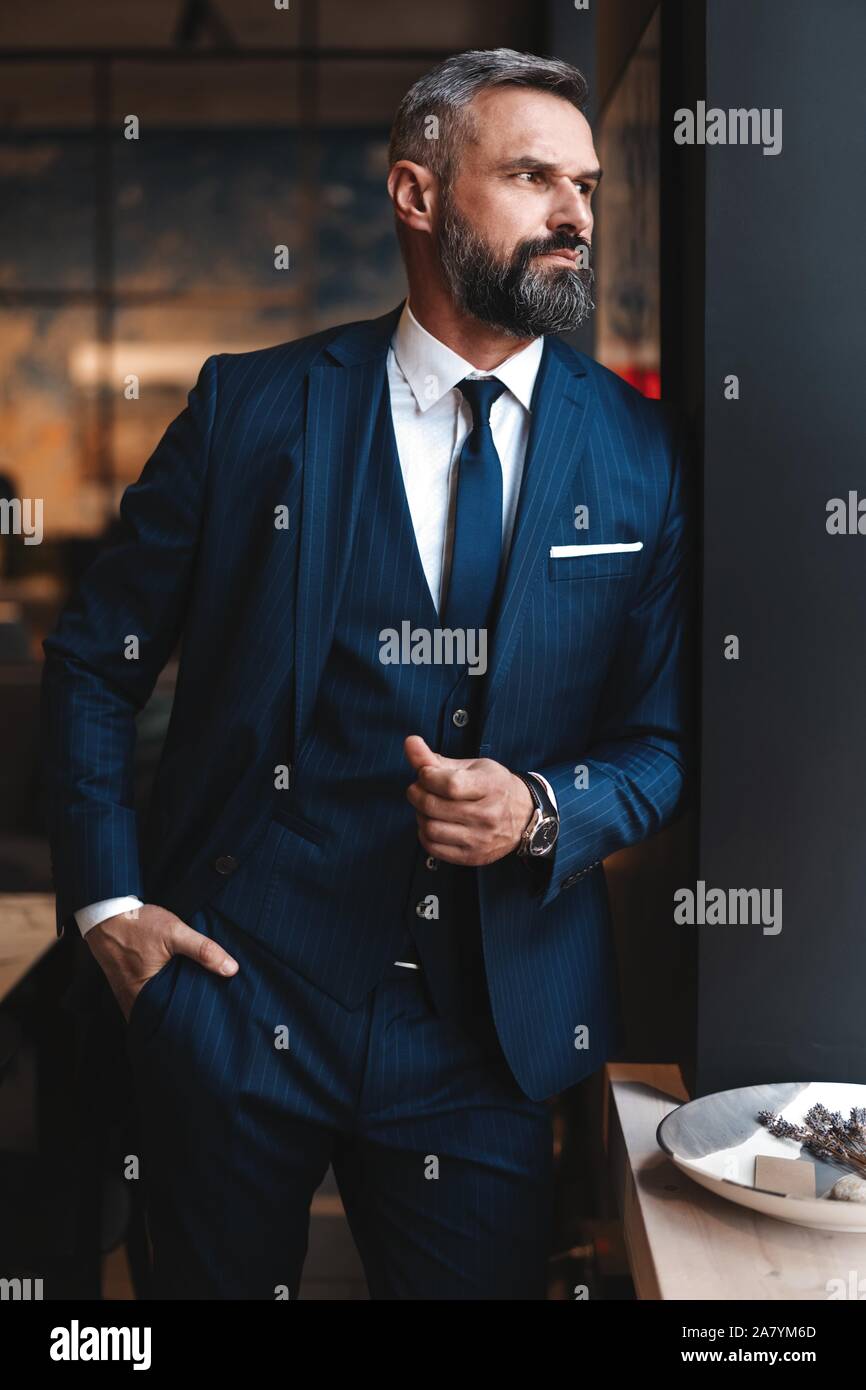 Stylish bearded man in a suit standing in modern office Stock Photo - Alamy