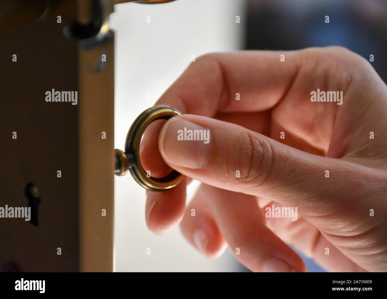 Hand of a woman turning a key on a door Stock Photo - Alamy