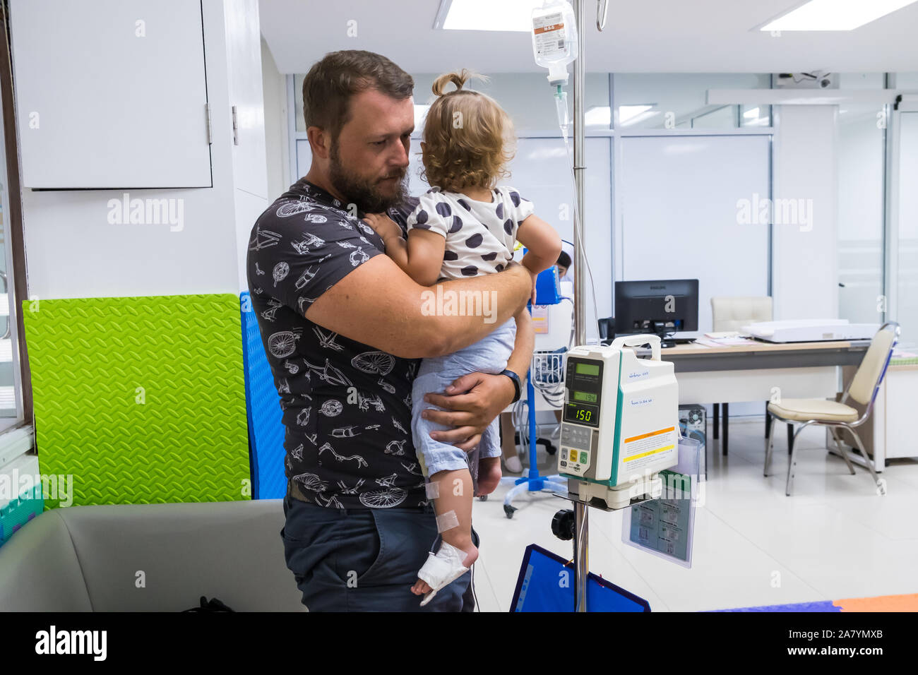 Surviving sad Dad and crying little daughter in hospital. A little girl ...
