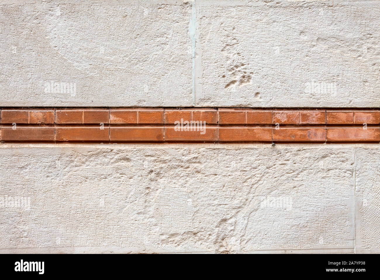 Stone wall with a line of bricks Stock Photo - Alamy