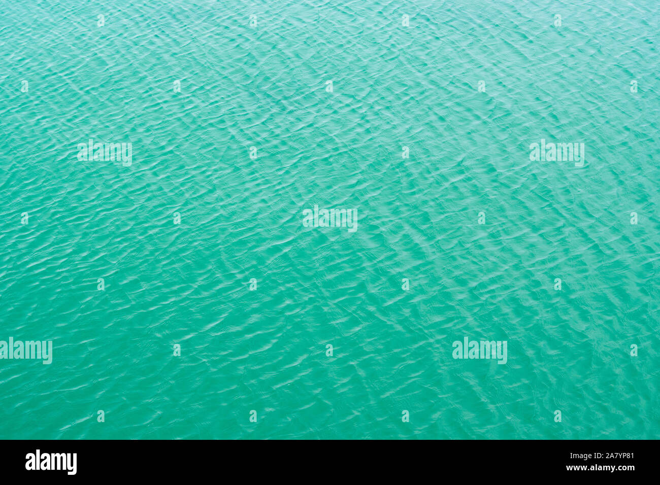 View of gentle ripples on an aqua coloured water surface suitable as a ...