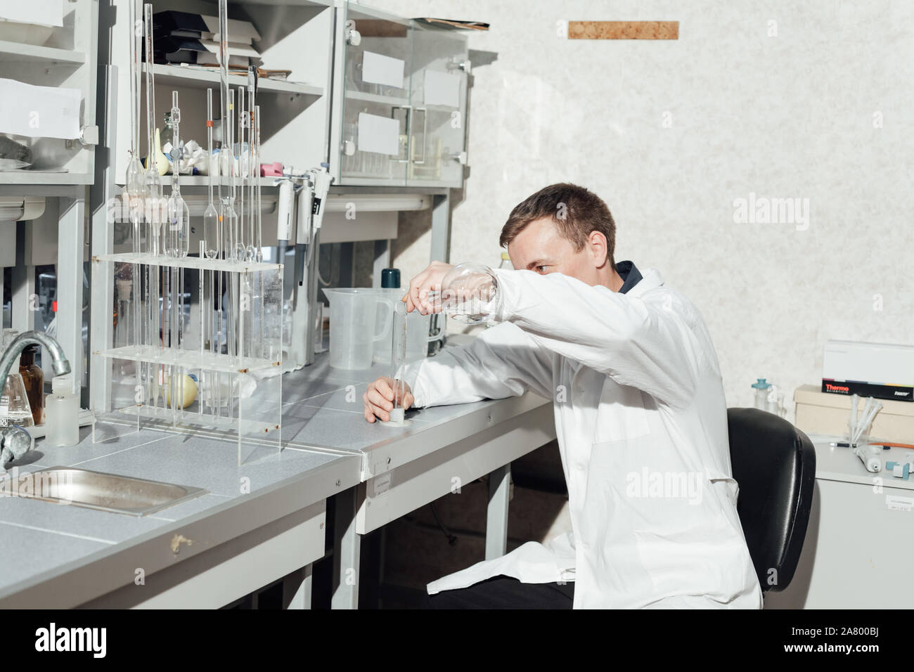 male scientist conducts chemical experiments in medical laboratory ...