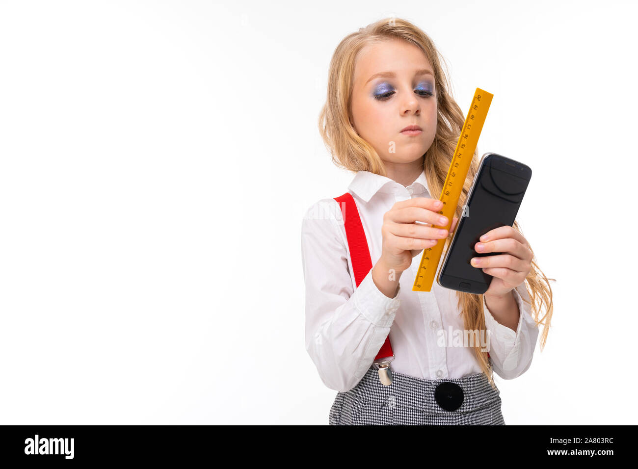 little blonde girl measures the line phone Stock Photo - Alamy