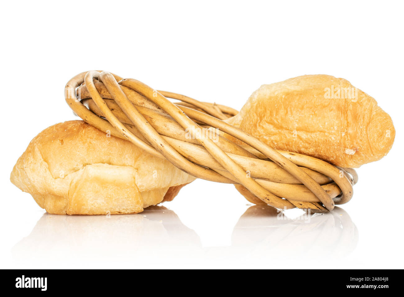 Group of two whole fresh baked mini croissant in wicker vine circle ...