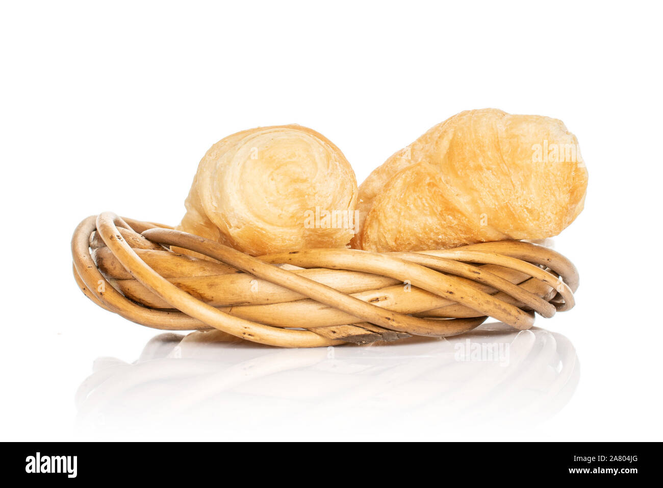 Group of two whole fresh baked mini croissant in wicker vine circle ...