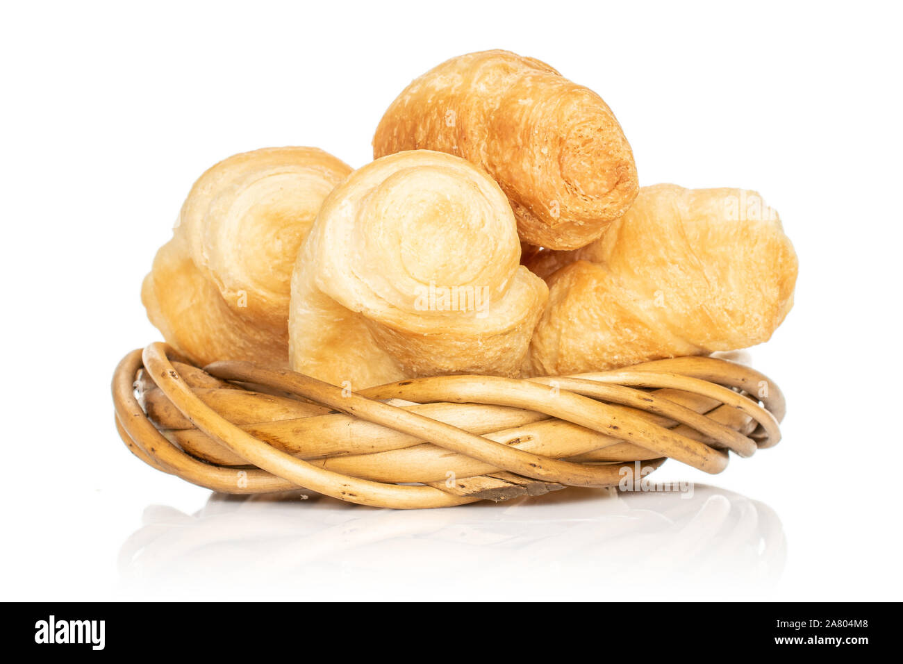 Group of four whole fresh baked mini croissant in wicker vine circle ...