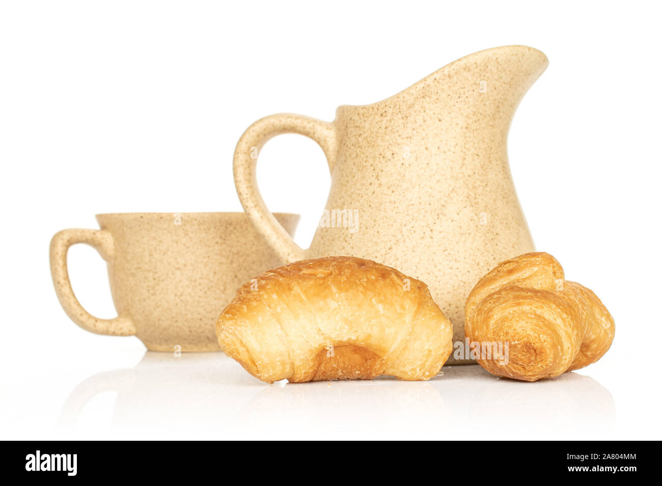 Group of two whole fresh baked mini croissant with ceramic jug and cup ...