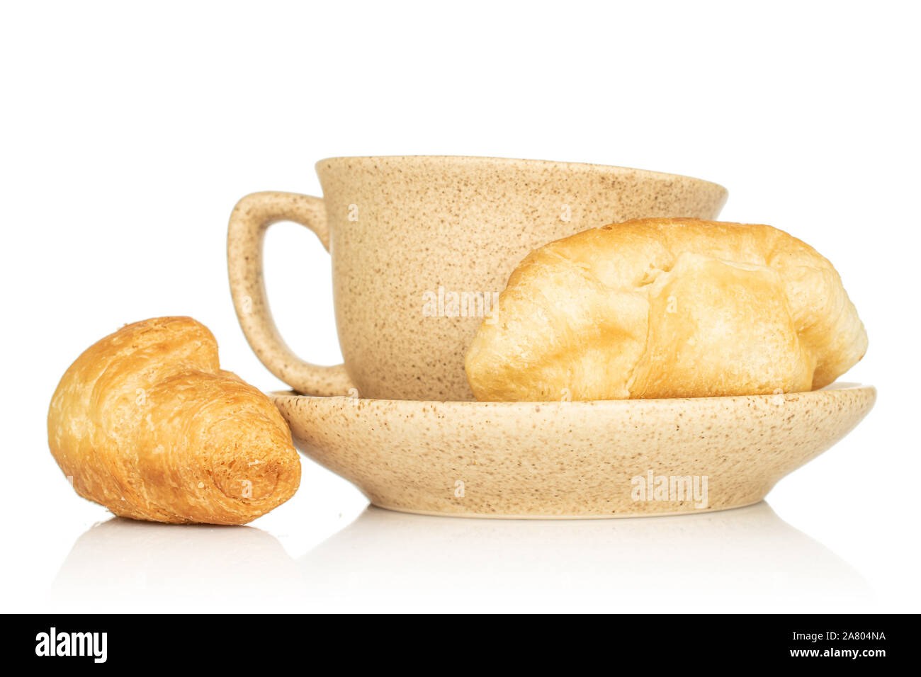 Group of two whole fresh baked mini croissant with cup and saucer ...