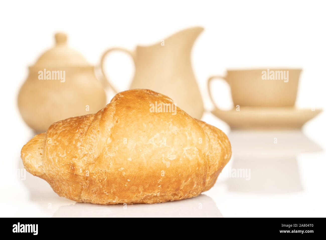 One whole fresh baked mini croissant with sugar bowl , ceramic jug and ...