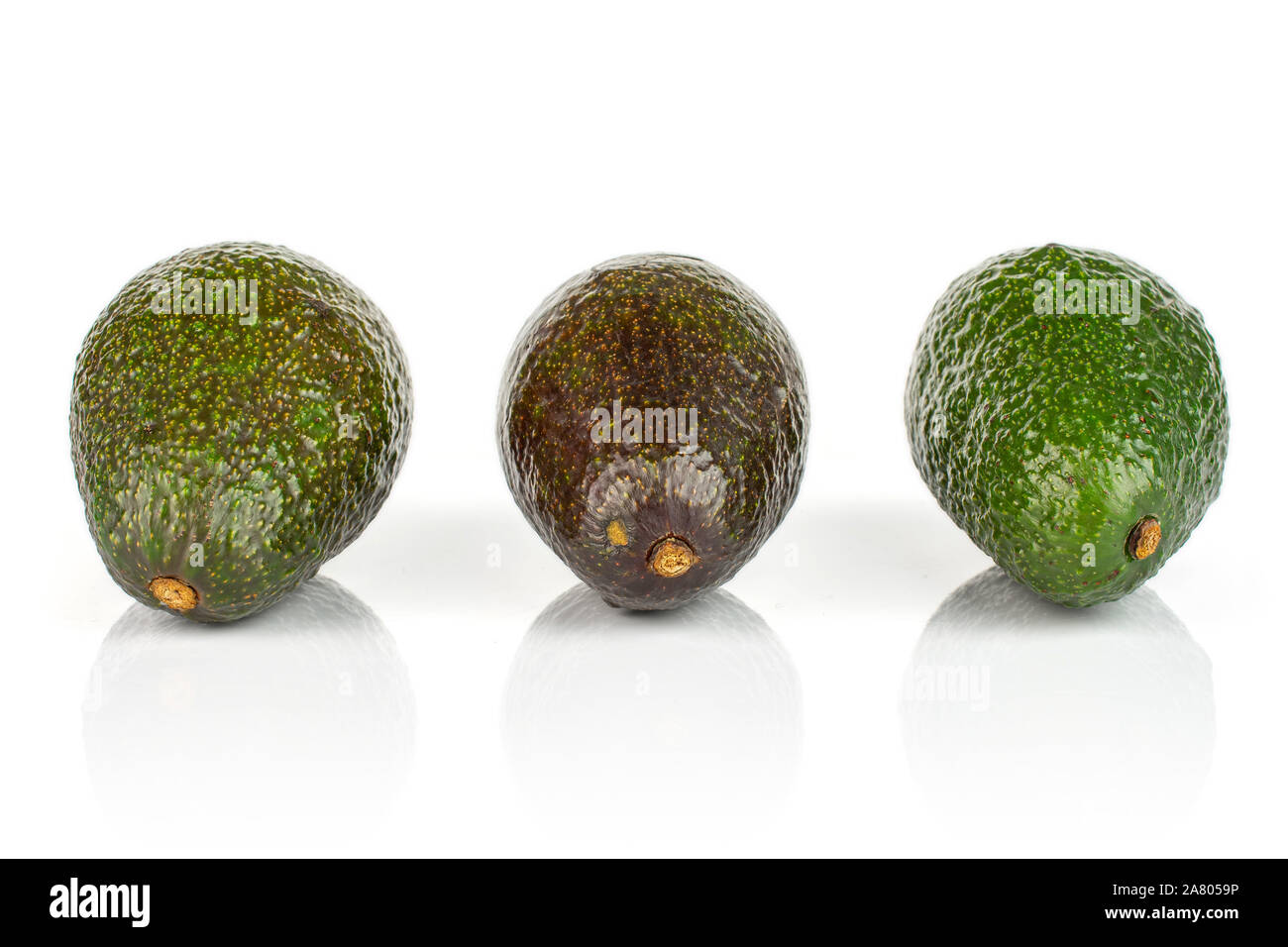 Group of three whole fresh green avocado in row isolated on white ...