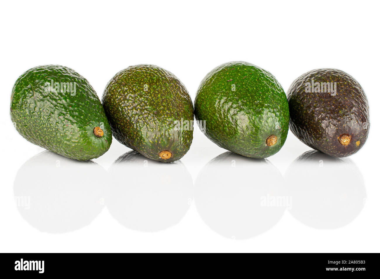 Group of four whole fresh green avocado in row isolated on white ...