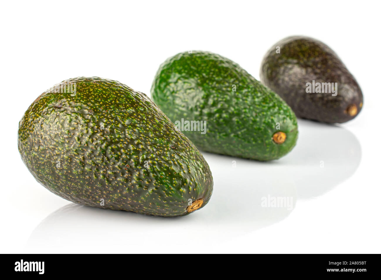 Group of three whole fresh green avocado placed diagonally isolated on ...