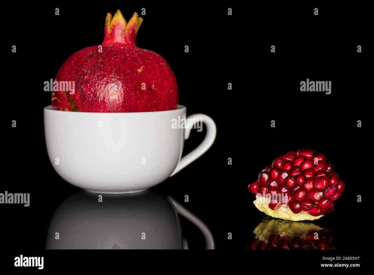 Group of one whole one piece of fresh red pomegranate in white ceramic ...