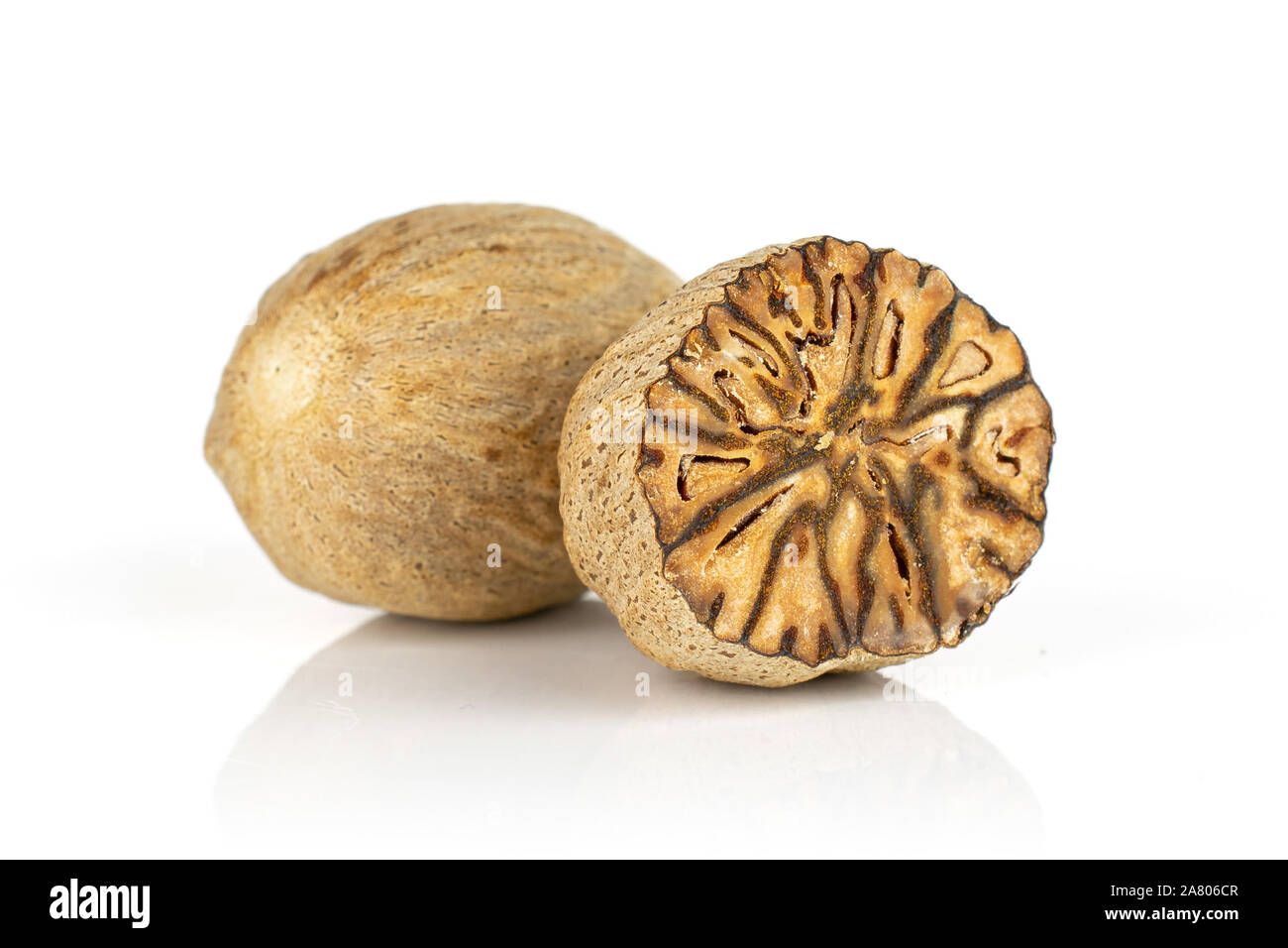 Group of one whole one half of dry brown nutmeg isolated on white ...