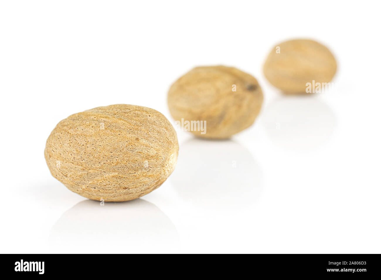 Group of three whole dry brown nutmeg isolated on white background ...