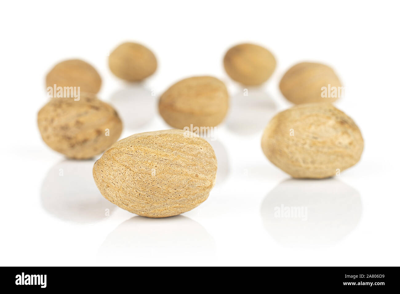 Group of eight whole dry brown nutmeg isolated on white background ...