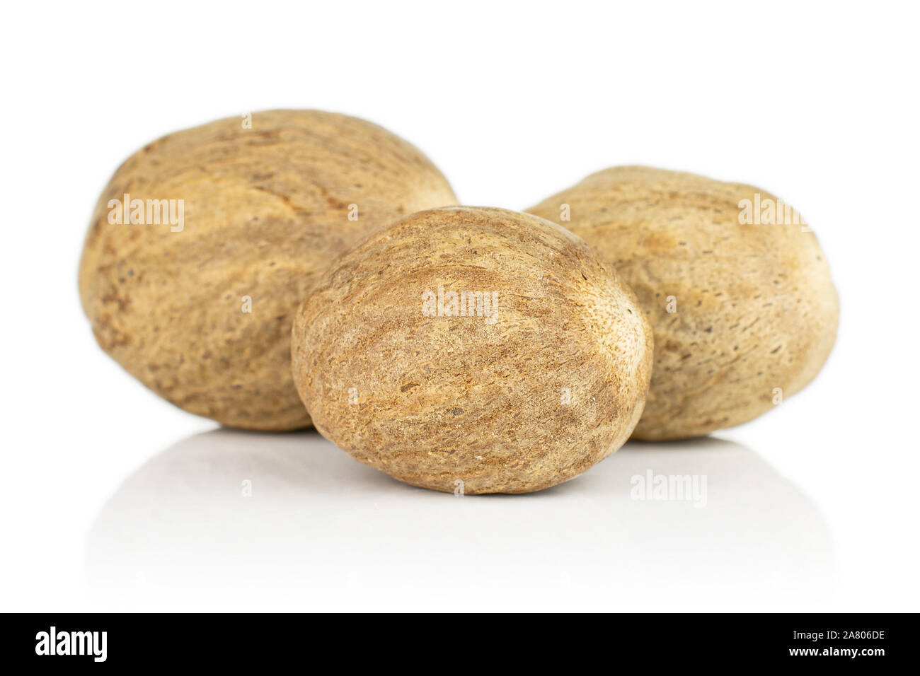 Group of three whole dry brown nutmeg isolated on white background ...