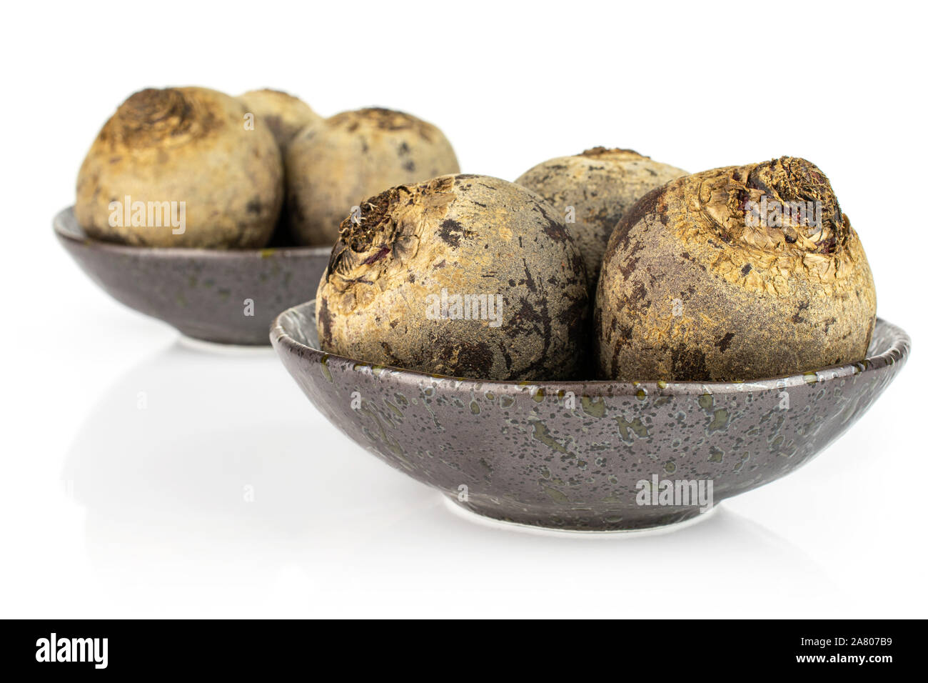 Group of six whole raw red beetroot in dark ceramic bowl isolated on ...