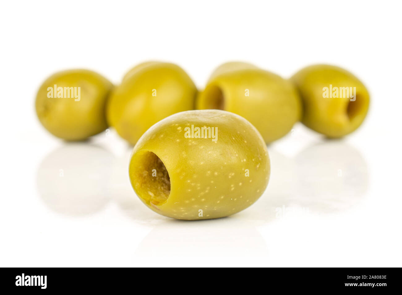 Lot of whole pitted green olive one in focus isolated on white ...