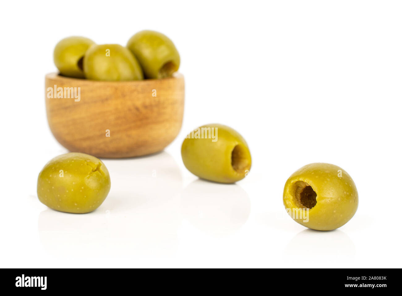 Group of six whole pitted green olive in tiny wooden bowl isolated on ...