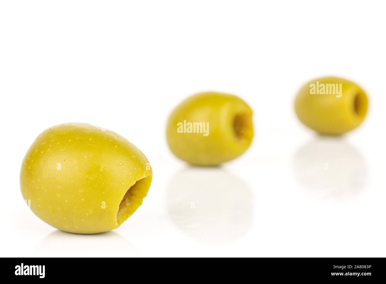 Group of three whole pitted green olive isolated on white background ...
