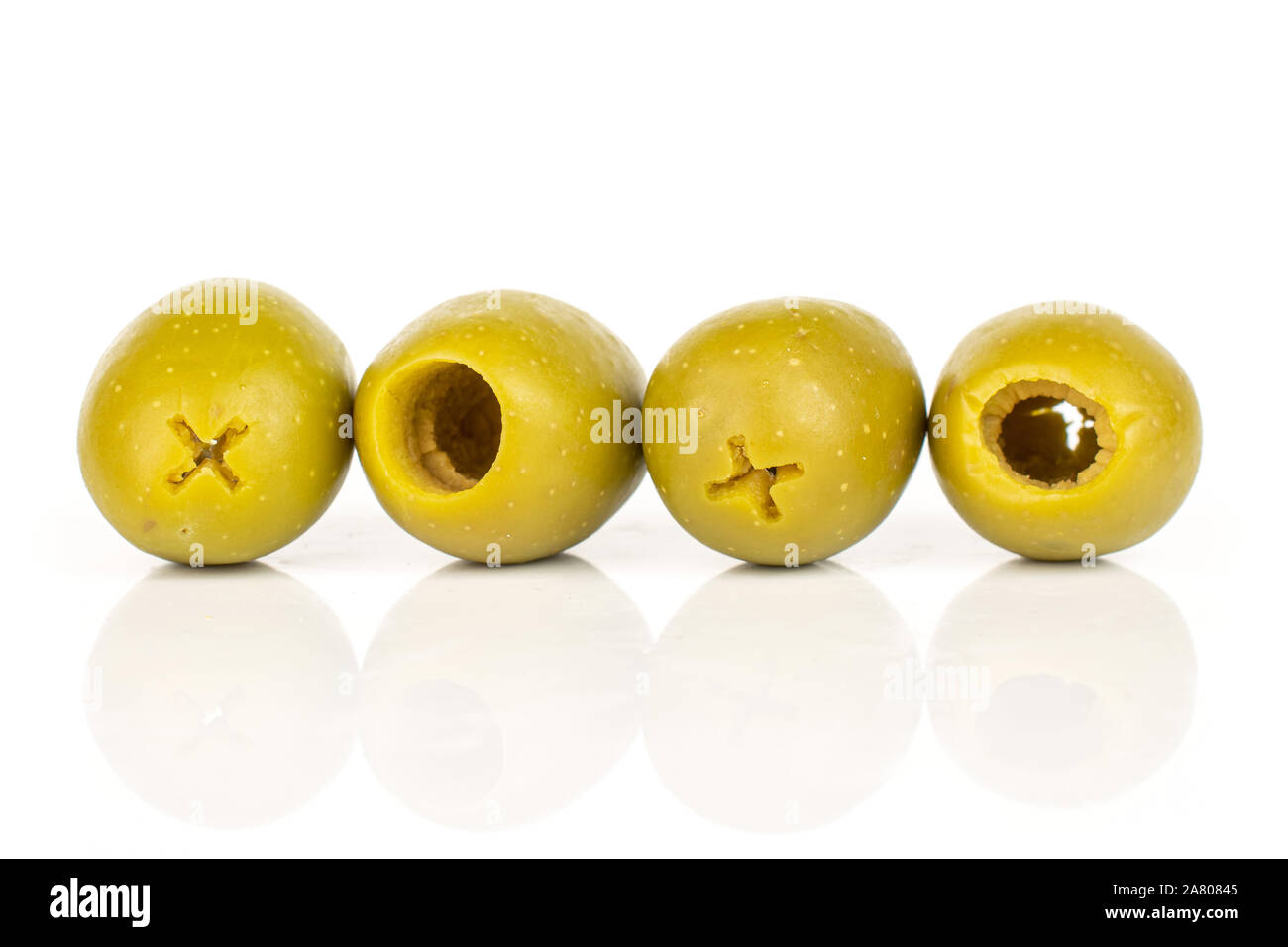Group of four whole pitted green olive isolated on white background ...