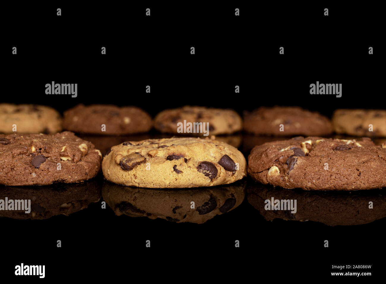 Group of eight whole sweet brown cookie isolated on black glass Stock ...