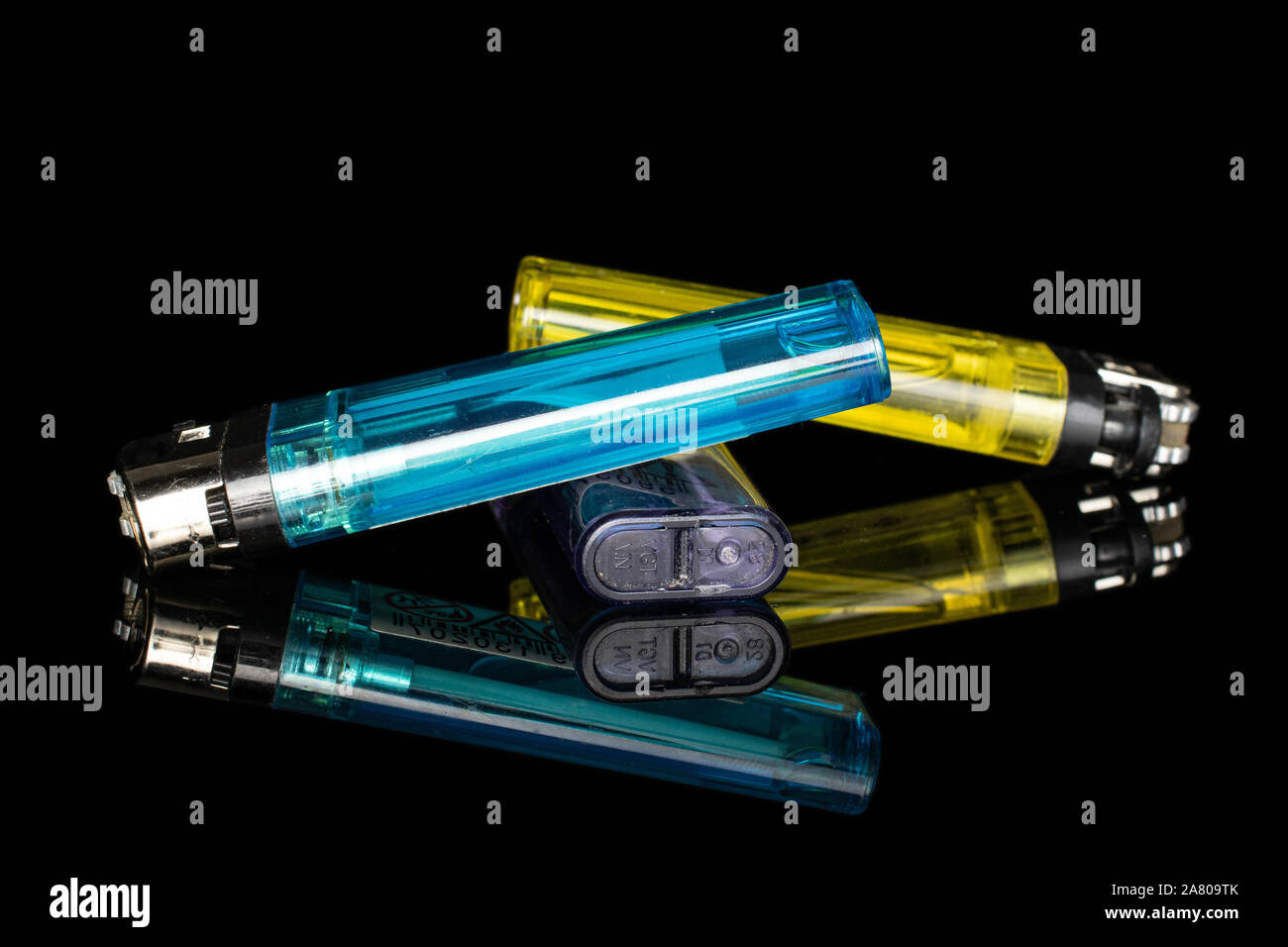 Group of three whole plastic lighter isolated on black glass Stock ...