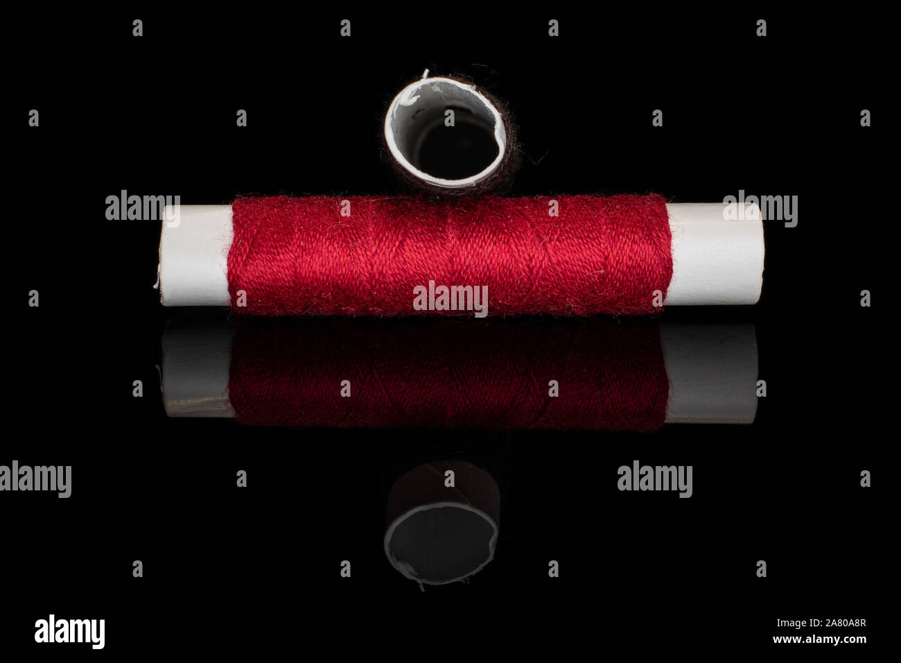 Group of two whole sewing thread spool isolated on black glass Stock ...