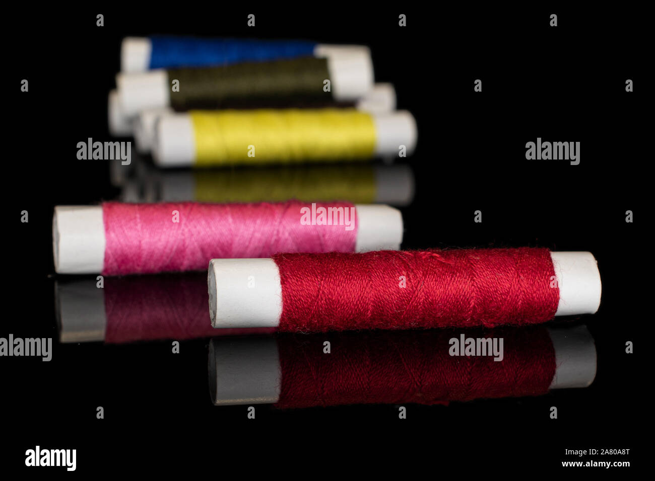 Group of seven whole sewing thread spool isolated on black glass Stock ...