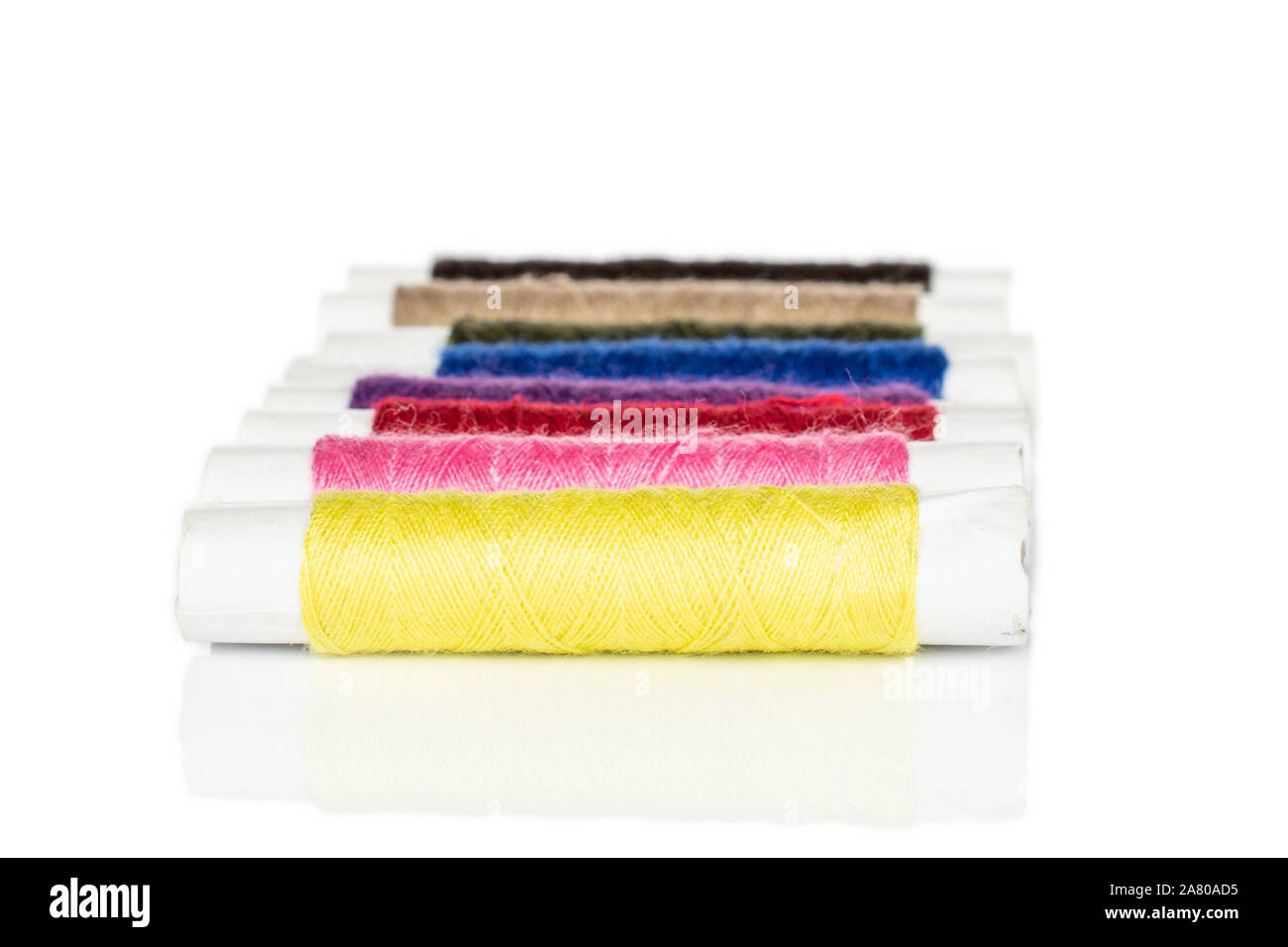 Group of eight whole sewing thread spool in row isolated on white ...