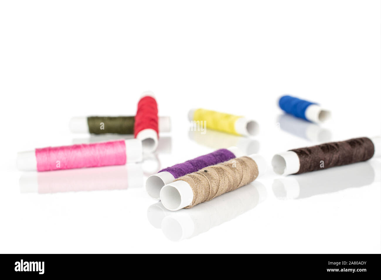 Group of eight whole colored sewing thread spool isolated on white ...