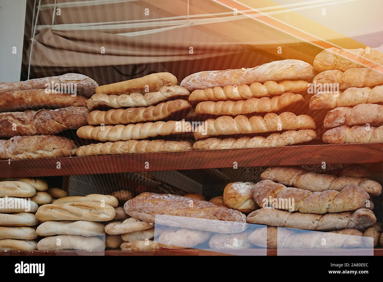 View of the glass case of bakery with various types of fresh bread ...