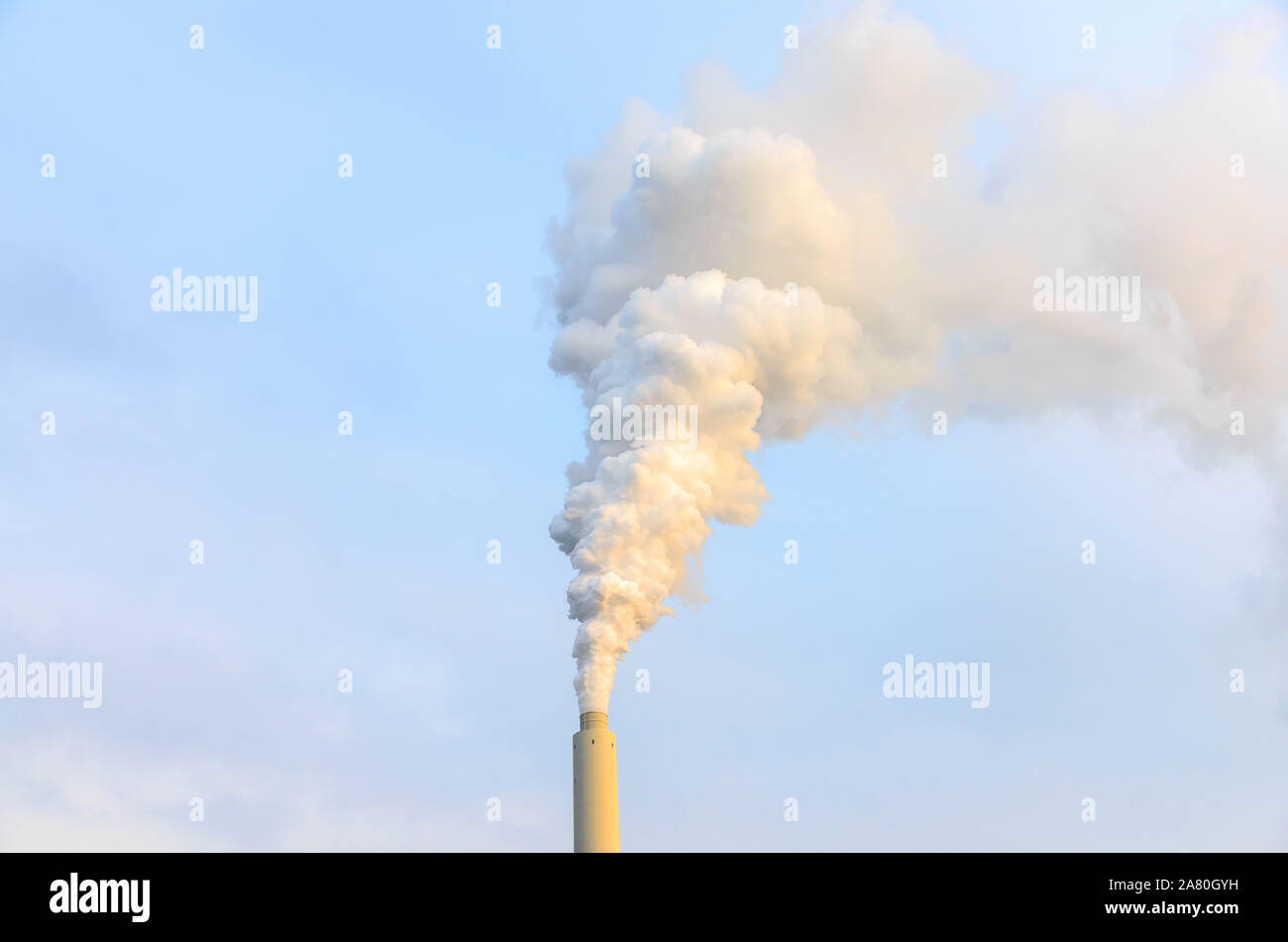 Smoke billowing from an industrial chimney into a smoky sky in a ...