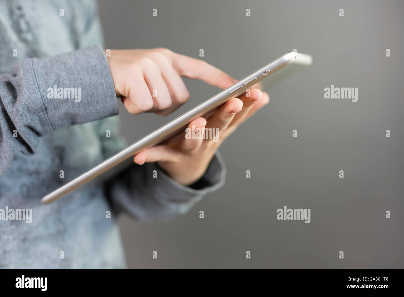 Boy uses silver tablet computer Stock Photo - Alamy