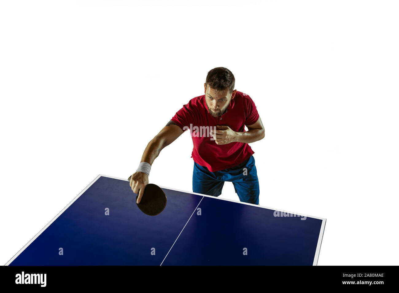 Young man plays table tennis on white studio background. Model in ...